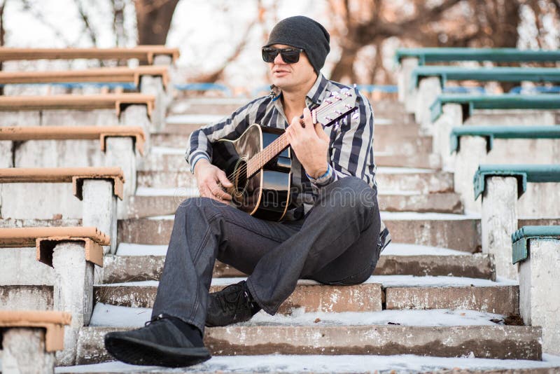 Young Man Sitting on Steps Playing Guitar and Singing, Music Concept ...