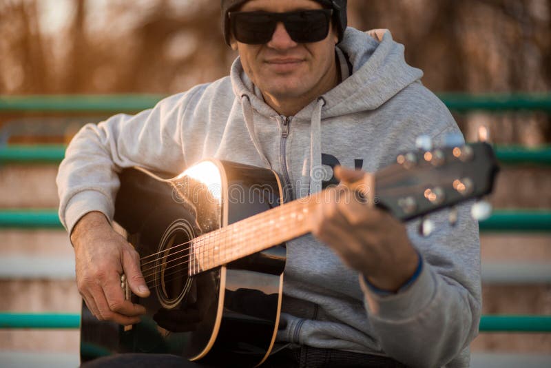 Young Man Sitting on Steps Playing Guitar and Singing Stock Photo ...