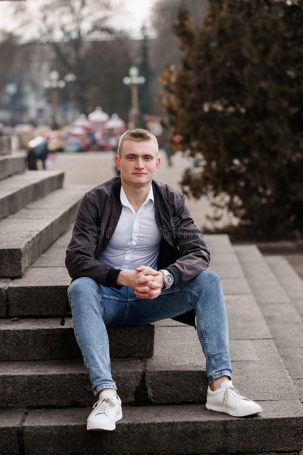 Young Man Sitting on Steps in Urban Park Setting Stock Photo - Image of ...
