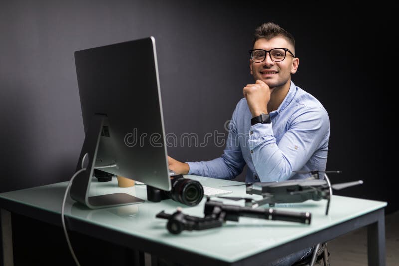 Young Man Sitting at Table with Different Devices and Gadgets at Office ...