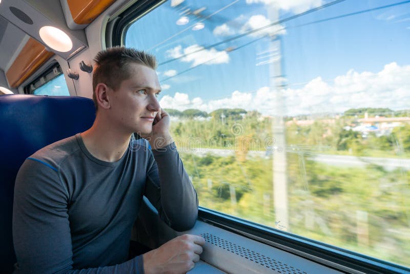 Young Man Sitting in the Train and Looks Out the Window Stock Image ...