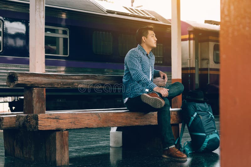 Young Man Sitting at Train Station with Awaiting the Train`s Arr Stock ...