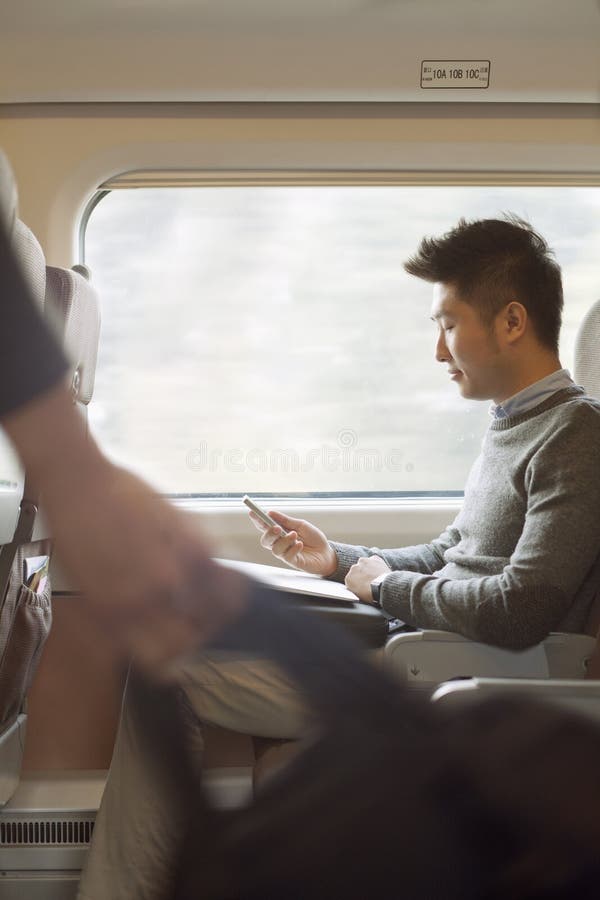 Young Man Sitting on a Train Using His Phone Stock Image - Image of ...