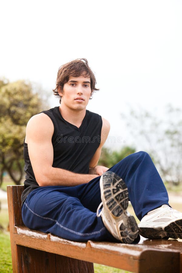 Young Man Sitting on Wooden Bench Stock Photo - Image of caucasian ...