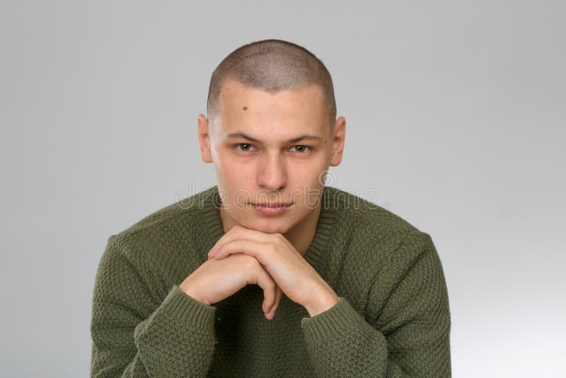 A Young Man is Skinhead in a Green Military Style Sweater. Studio ...