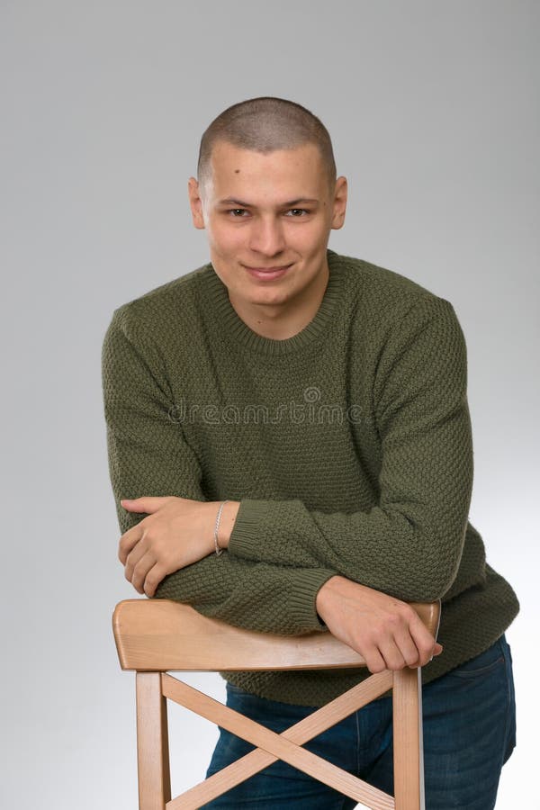 A Young Man is Skinhead in a Green Military Style Sweater. Studio ...
