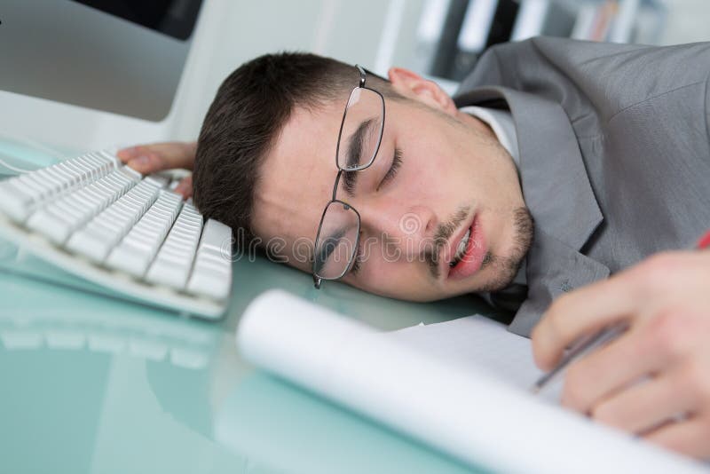 Young man sleeping at desk stock image. Image of tired - 99651201 Young man sleeping at desk stock image. Image of tired - 99651201