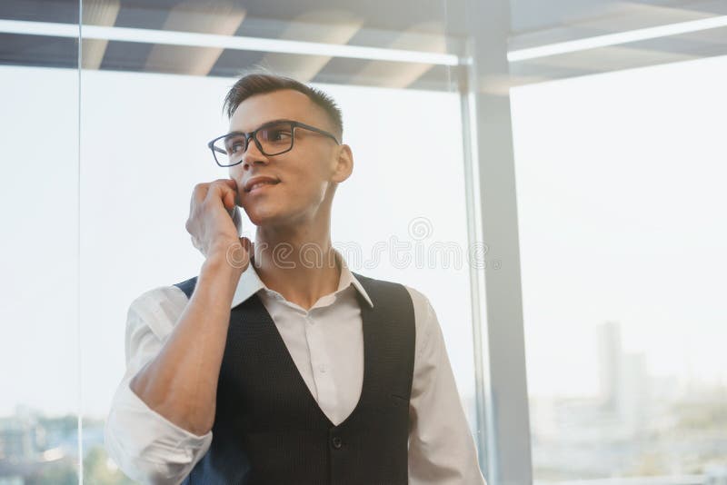 Young Man with a Smartphone Standing in the Office. Stock Photo - Image ...