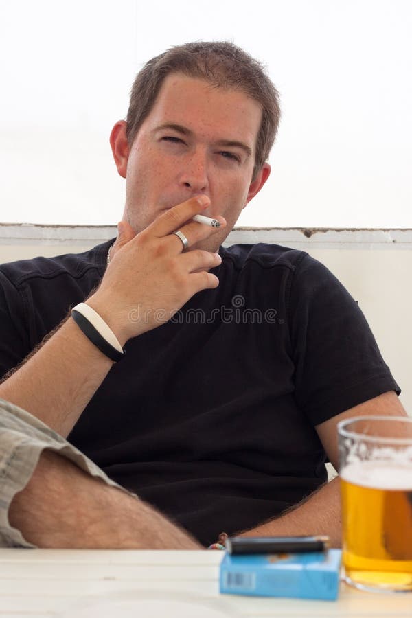 Young Man Smoking Cigarette Stock Image - Image of indoors, holding ...