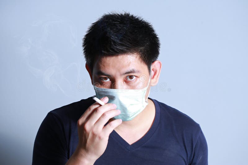 Young Man Smoking Cigarette with Protective Mask Stock Photo - Image of ...