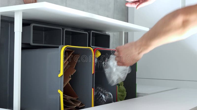 A Young Man Sorts Garbage in Containers in the Kitchen. Modern Kitchen ...