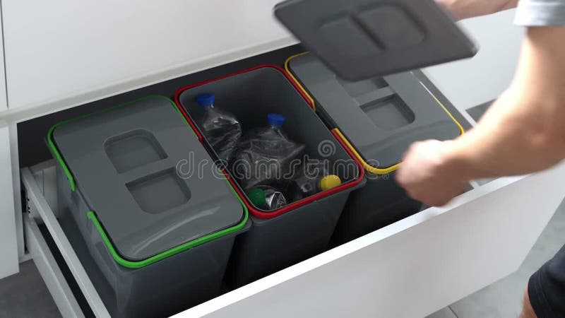 A Young Man Sorts Garbage in Containers in the Kitchen. Modern Kitchen ...