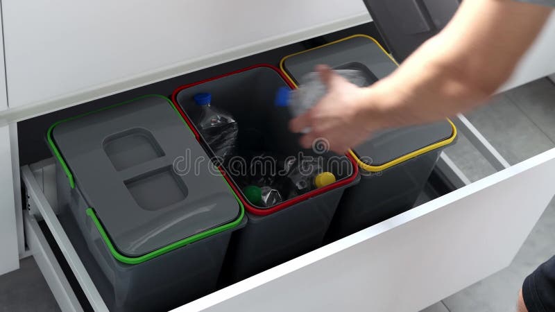 A Young Man Sorts Garbage in Containers in the Kitchen. Modern Kitchen ...