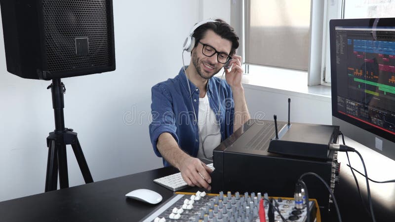 Young Man in Sound Recording Studio. Sit at Table and Adjusting Mixing ...