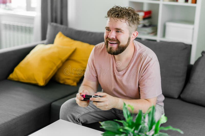 Young Man Spending Time at Home, Sitting on a Couch in Apartment and ...