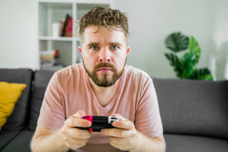 Young Man Spending Time at Home, Sitting on a Couch in Apartment and ...