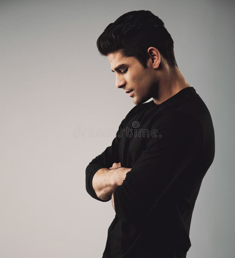 Young Man Standing with Arms Crossed Looking Down Stock Photo - Image ...