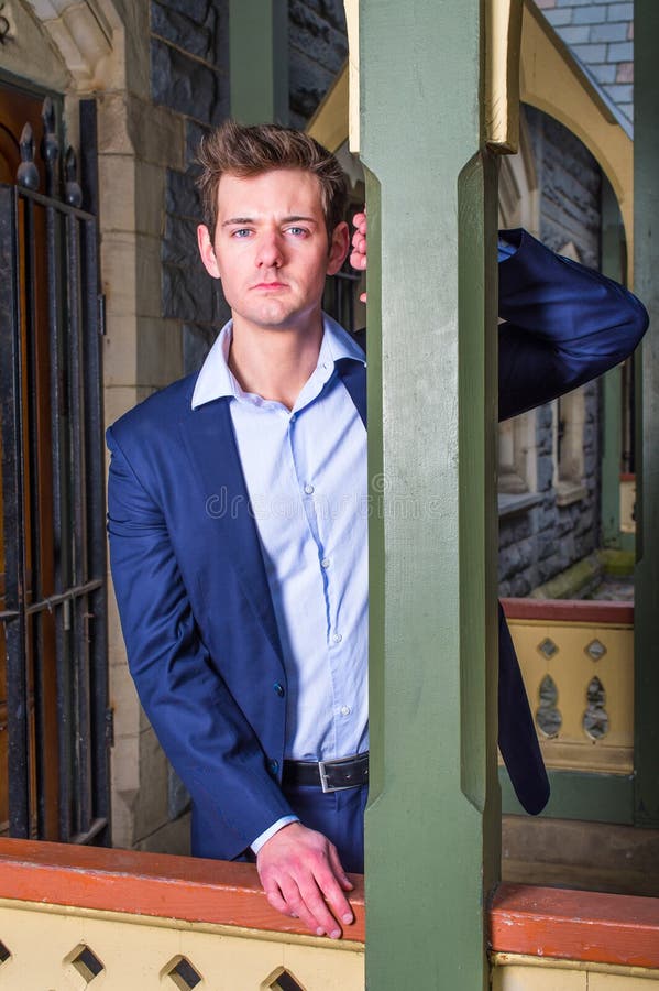 Young Man Standing by a Column at a Cottage, Looking Forward Stock ...