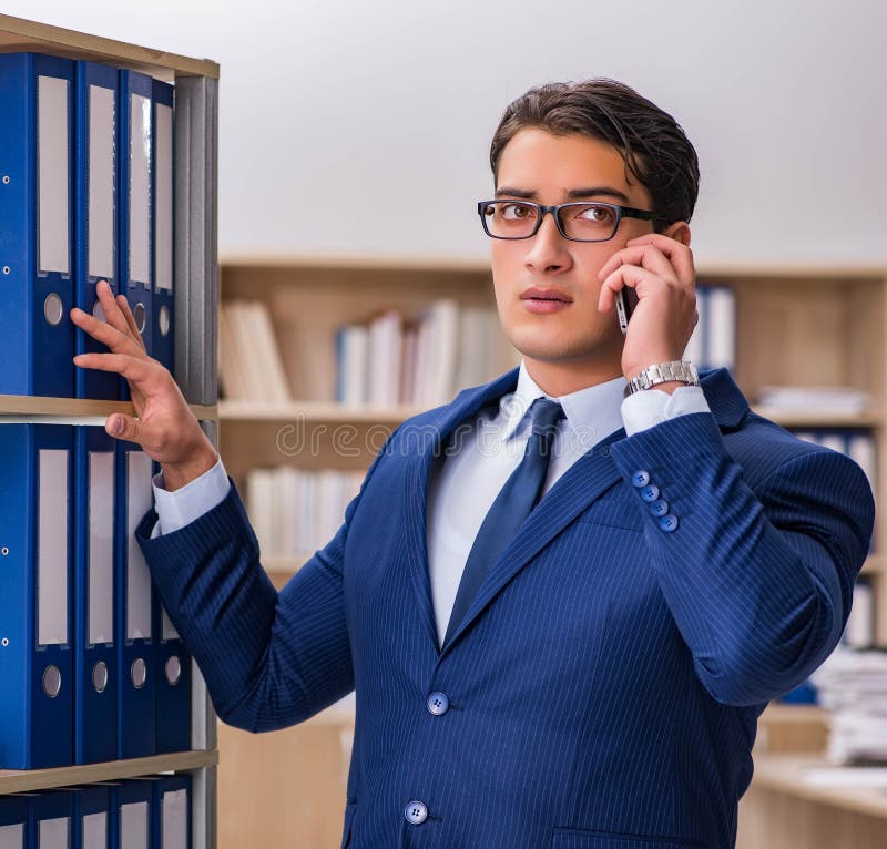 Young Man Standing Next To the Shelf with Folders Stock Image - Image ...