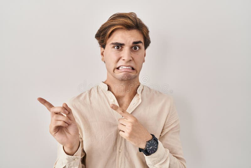 Young Man Standing Over Isolated Background Pointing Aside Worried and ...
