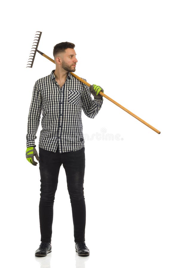 Young Man is Standing with Rake on a Shoulder and Looking To the Side ...