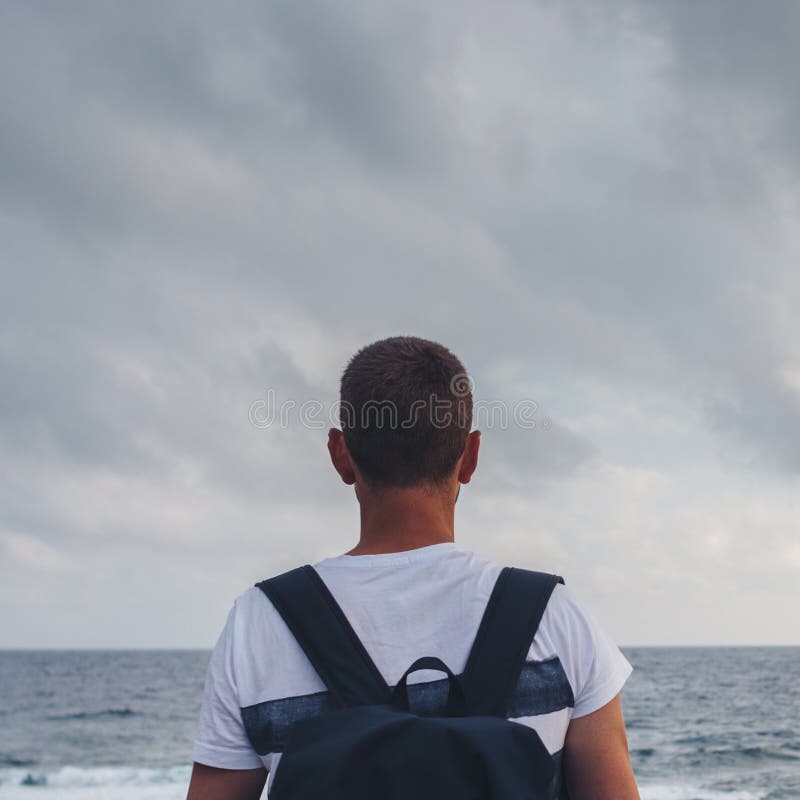 Young Man Standing by the Shore Looking at the Sea and the Sky. Stock ...