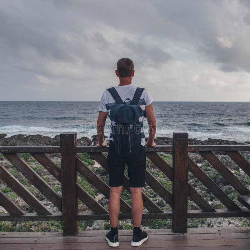 Young Man Standing by the Shore Looking at the Sea and the Sky. Stock ...