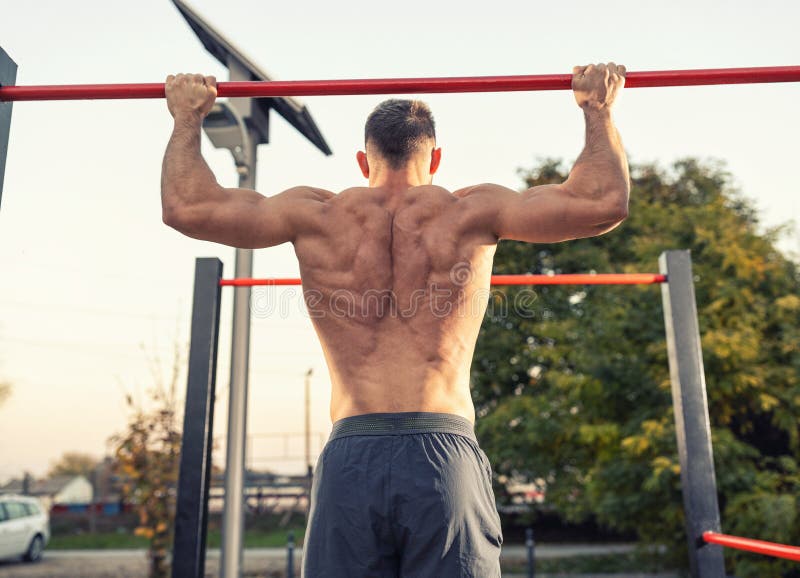 Young Man with Strong Back Muscles Doing Pull Ups on the Bar Outside ...
