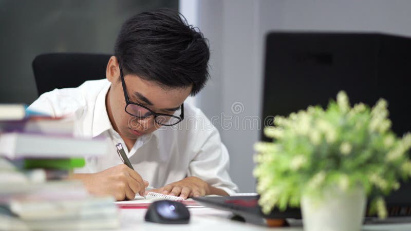 Man Studying and Writing on Notebook with Laptop Computer Stock Footage ...