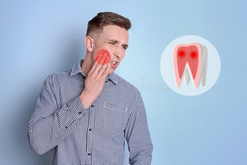 Young Man Suffering from Toothache on Light Blue Background Stock Photo ...