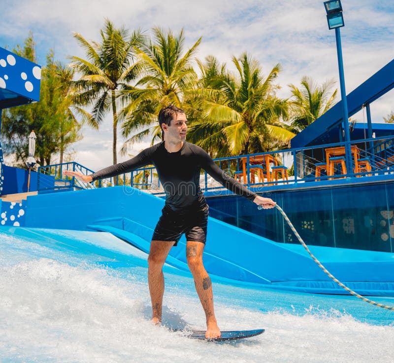 Young Man Surfing on a Wave Simulator at a Water Amusement Park Stock ...