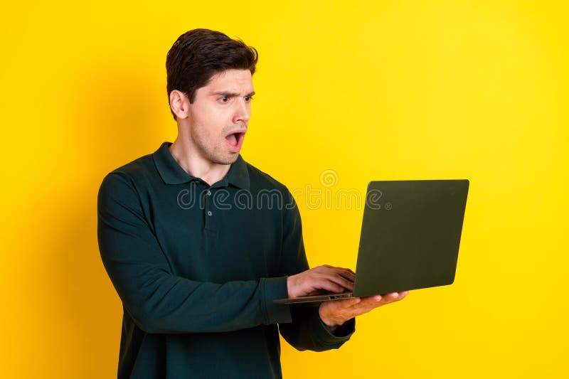 Young Man with a Surprised Expression Using a Laptop Computer Against a ...