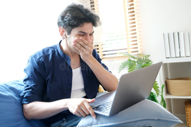 Young Man Surprising while Looking at Laptop Computer, Work at Home ...