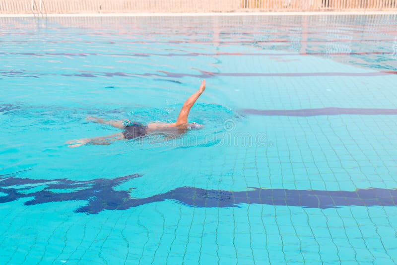 Young Man Swimming in the Swimming Pool . Fit Swimmer Training in the ...