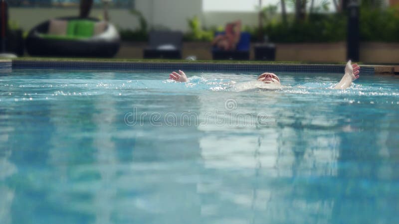 Young Man Swims on Back Along City View in Swimming Pool Stock Photo ...