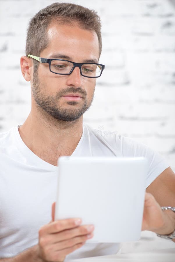 A young man with a tablet stock photo. Image of notebook - 58356406