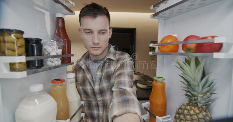 A Young Man Takes a Container with Breakfast from the Refrigerator ...