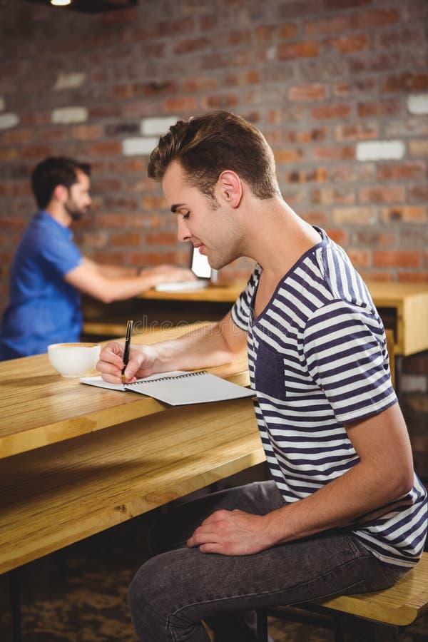 Young Man Taking Notes in His Notebook Stock Photo - Image of coffee ...