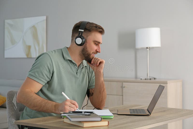 Young Man Reading Book in Armchair Indoors. Home Library Stock Photo ...