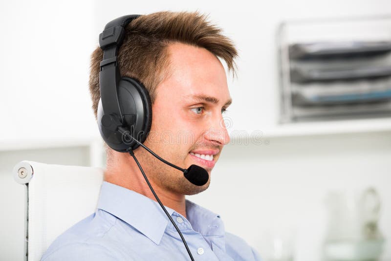 Young Man Talking on Headset at Office Stock Image - Image of ...