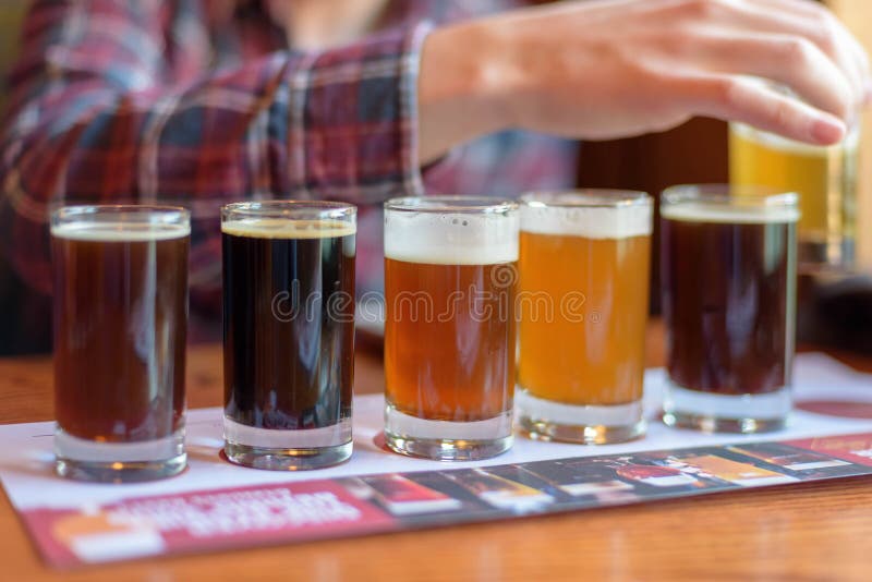 Young Man Tasting Beer Samples from a Beer Flight Stock Image - Image ...