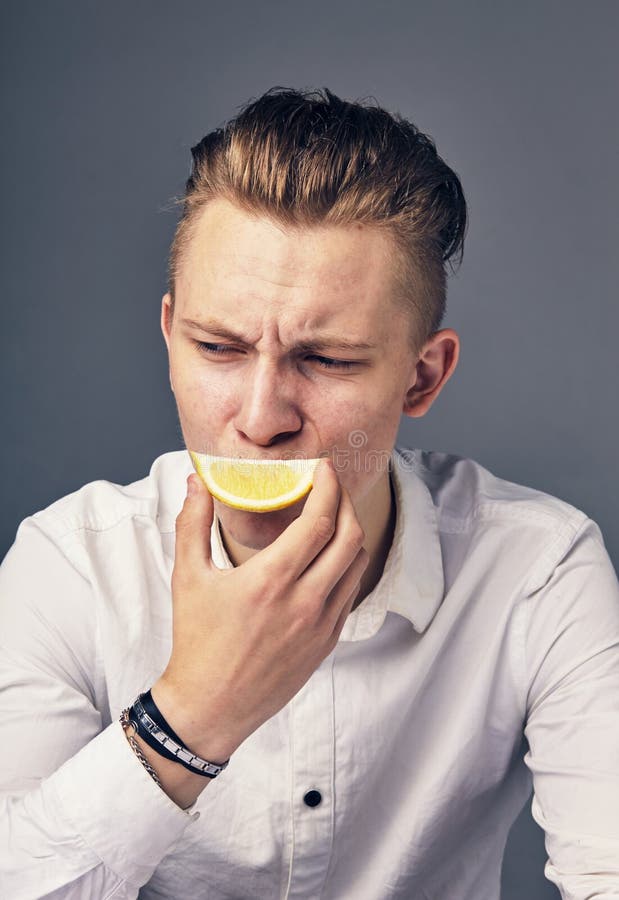 Young man tasting lemon. stock image. Image of handsome - 115215299