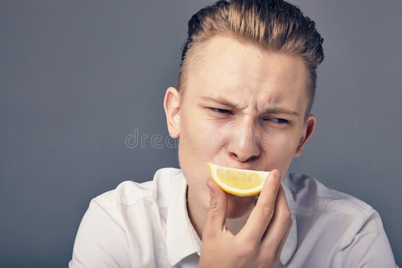 Young man tasting lemon. stock photo. Image of adult - 115277368