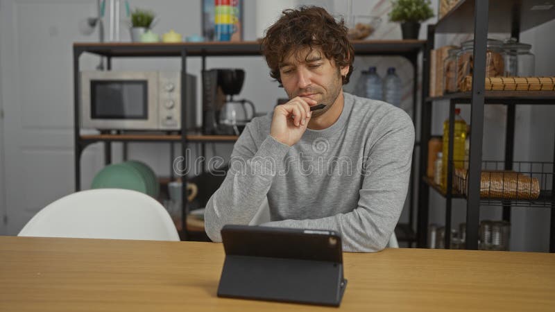 Young Man Thinking in Office Setting while Sitting at a Desk with ...