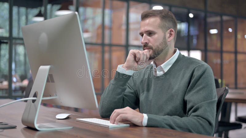 Young Man Thinking while Working on Computer Stock Photo - Image of ...