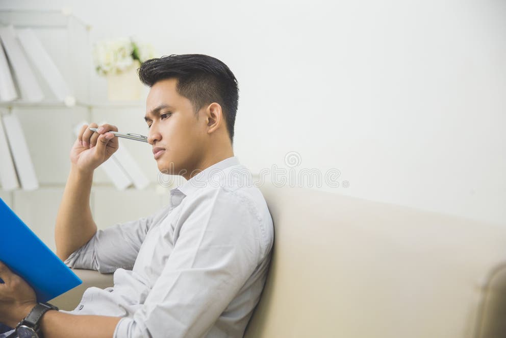 Young Man Thinking while Writing on a Book Stock Photo - Image of test ...