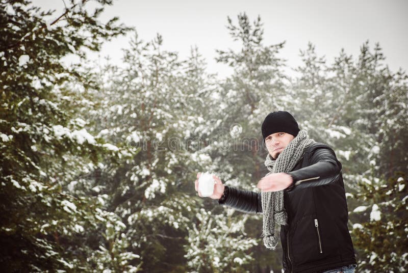A Young Man Throwing a Snowball in the Winter Forest Stock Photo ...