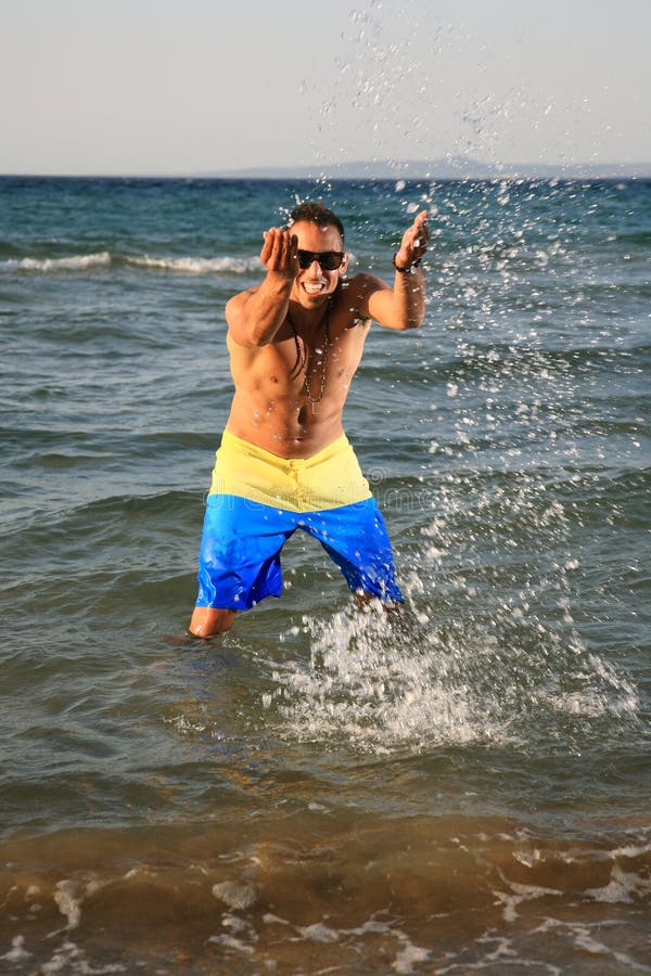 Young man throwing water stock image. Image of travel - 26150779