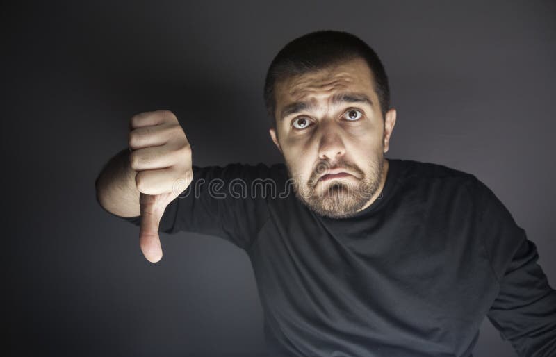 Young man thumbs down stock image. Image of person, shot - 110649091
