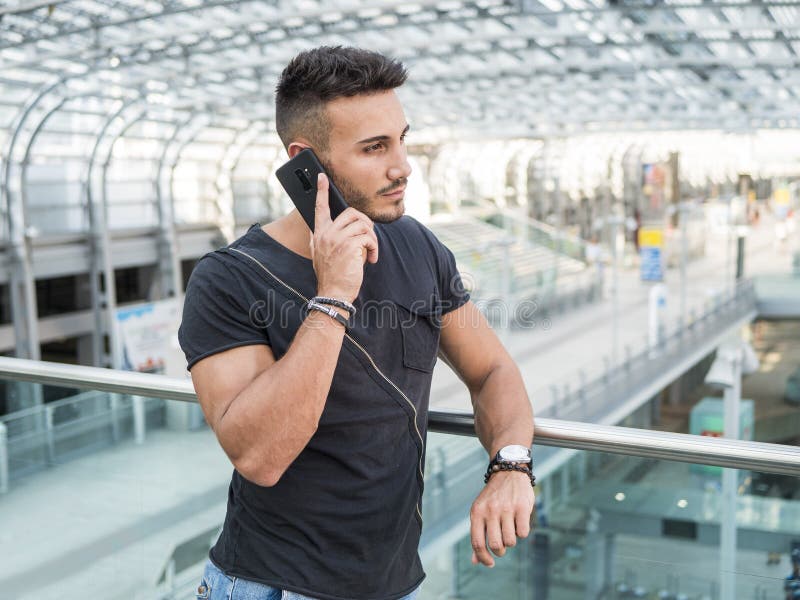 Young Man in Train Station Calling on Cellphone Stock Image - Image of ...